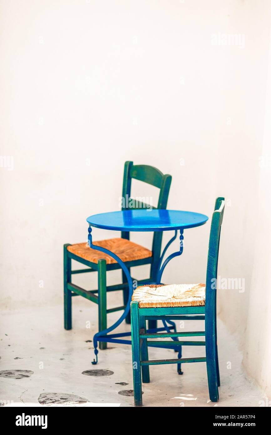 Chairs on street of typical greek traditional village with white houses ...