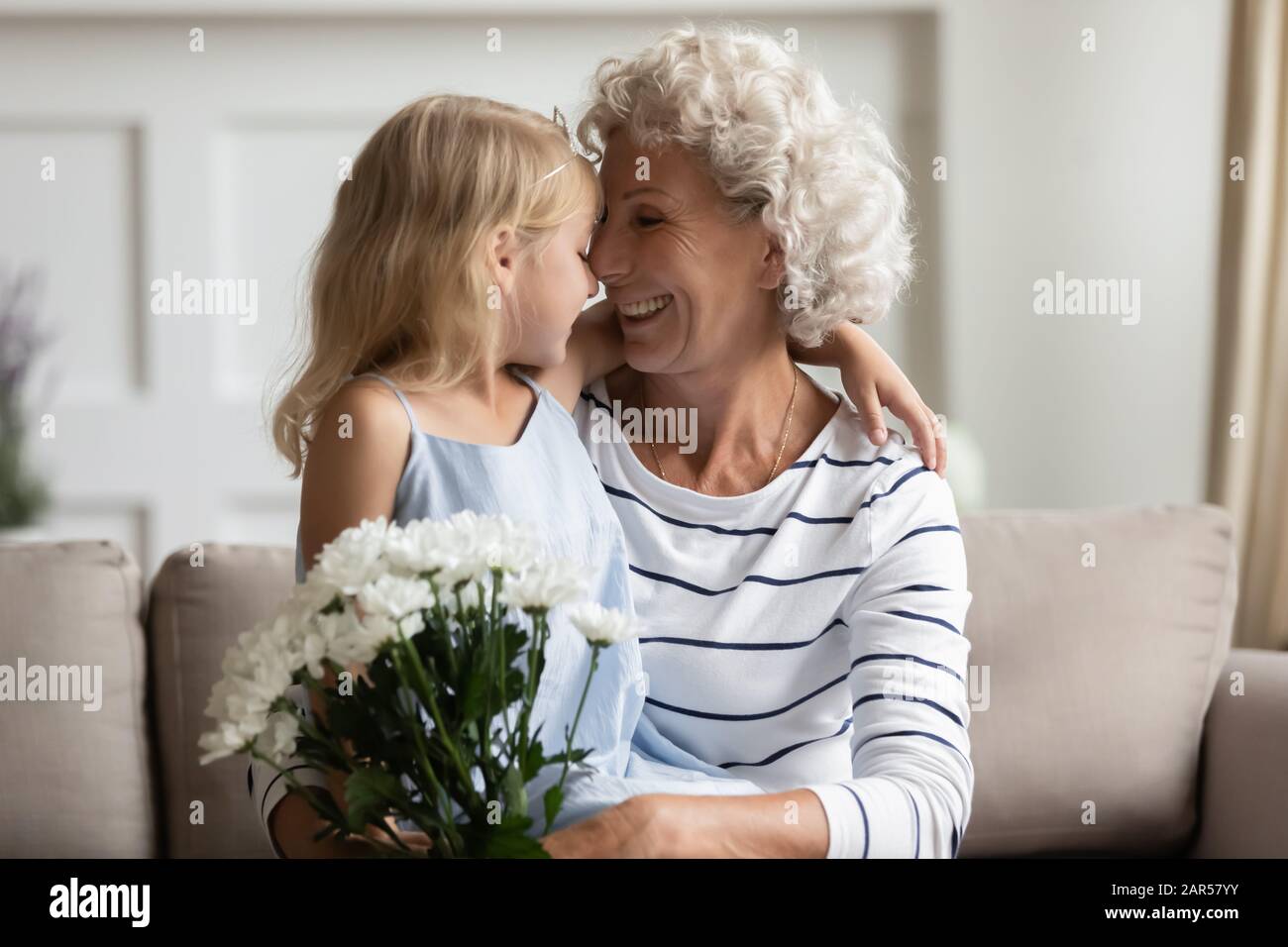 Happy affectionate middle aged grandma touching noses with ...