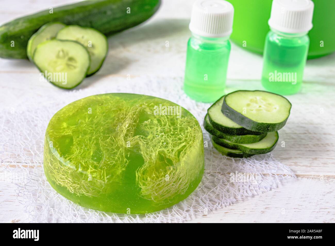 Cucumber extract in a bottle with a piece of soap and cucumber slices ...