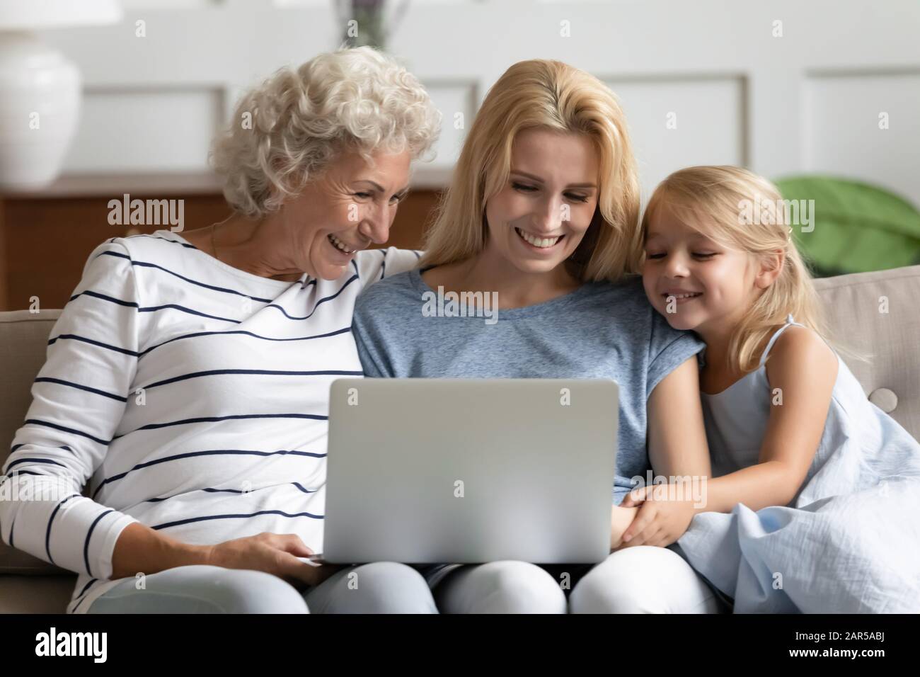 Happy three generations family looking at laptop screen Stock Photo - Alamy