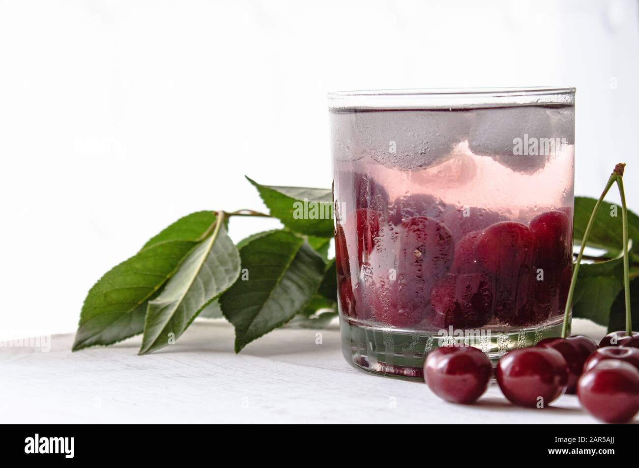 Fresh cherry cocktail with ice on a white wooden background. Fresh ...