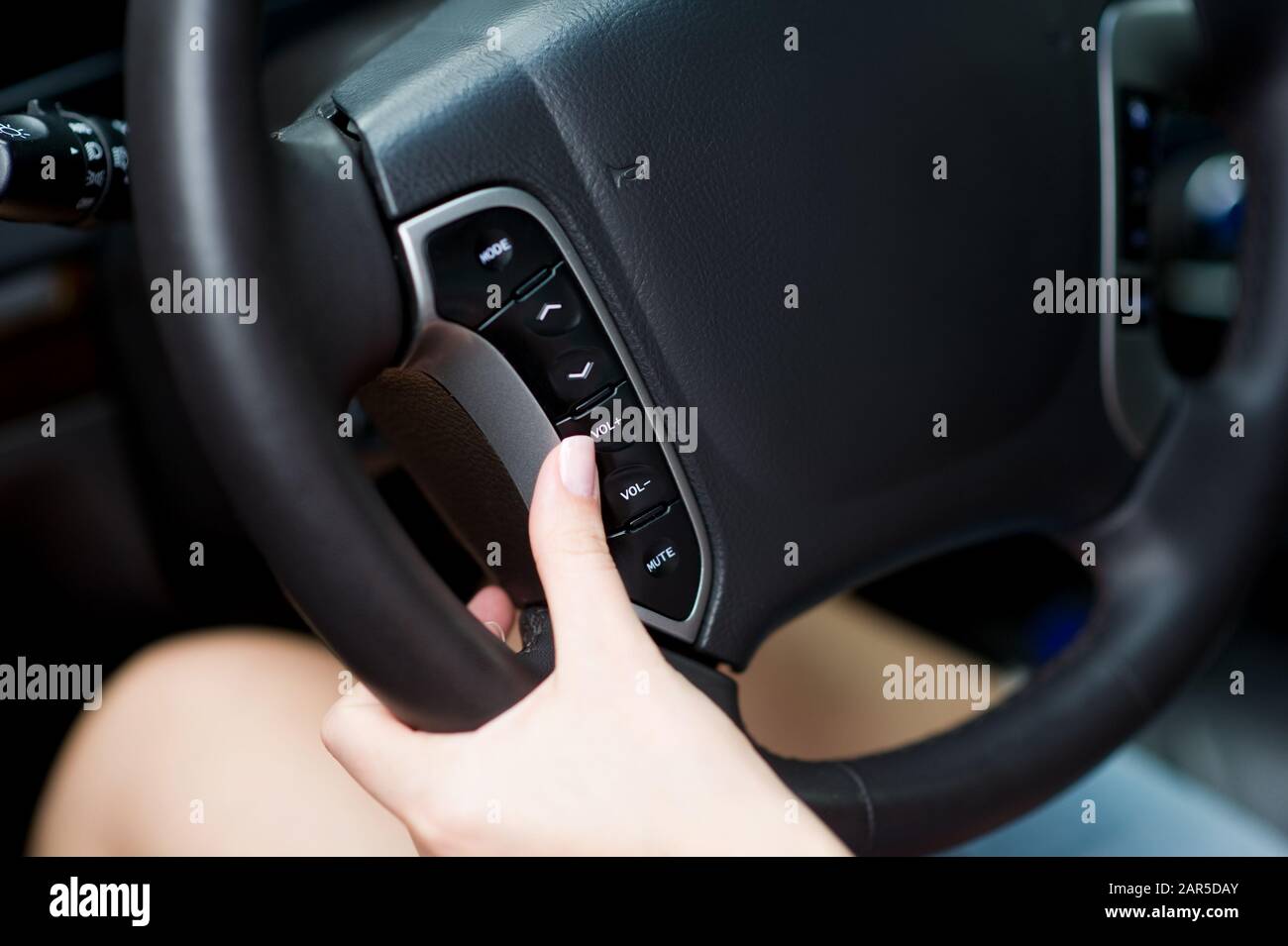 the driver adjusts the volume of the audio system in the car using the ...