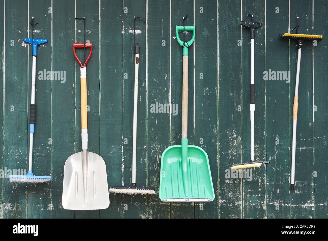 Winter tools like snow shovels, ice scrapers, and snow brushes hang ...