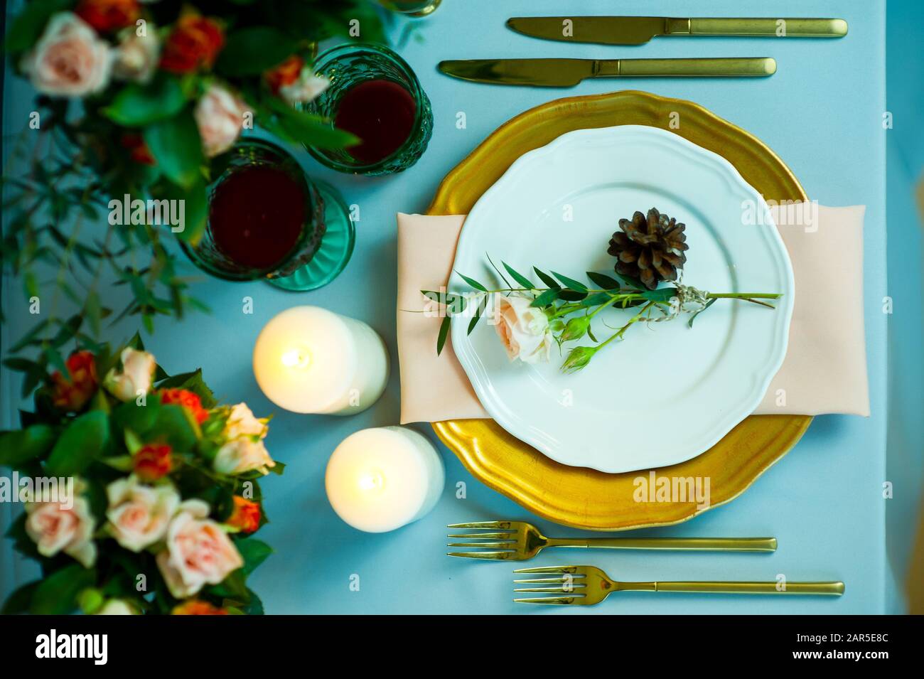 turquoise-colored table with gold plates and cutlery Stock Photo - Alamy