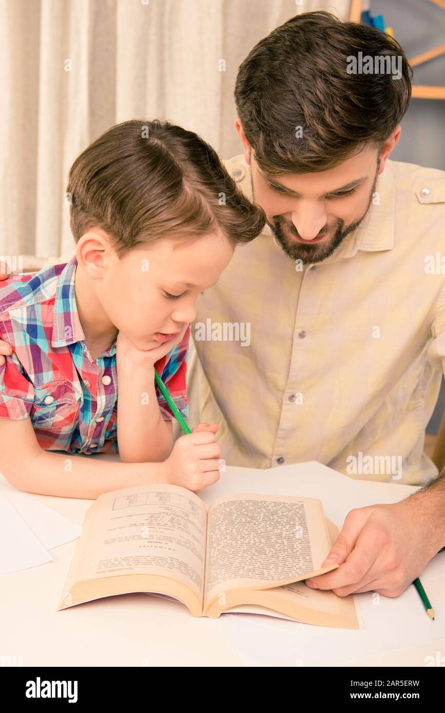 Close up portrait of handsome father reading book to his son Stock ...