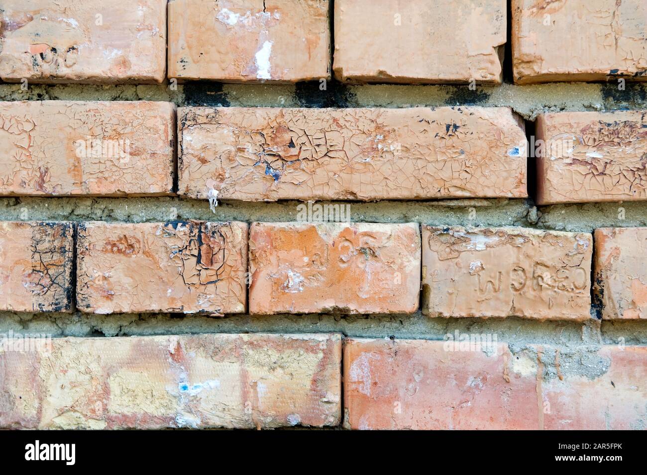 fragment of a brick wall of 4 lines of bricks, roughly laid out with ...