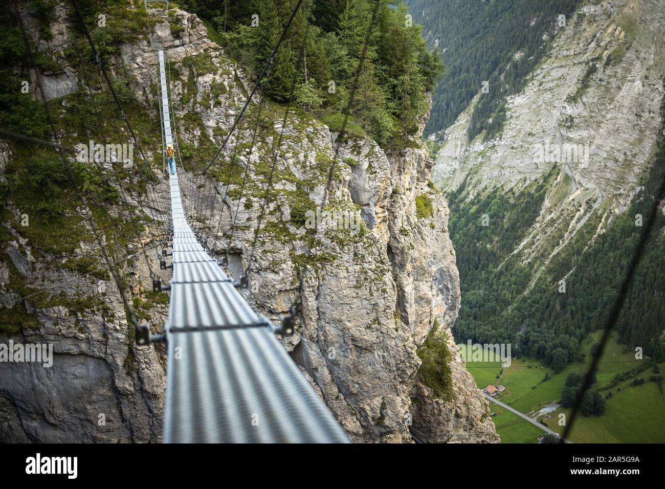 Pretty, female climber on a via ferrata - climbing on a rock in Swiss ...