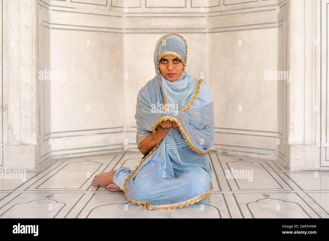 Young Indian woman praying outside Mosque dressed in colorful ...