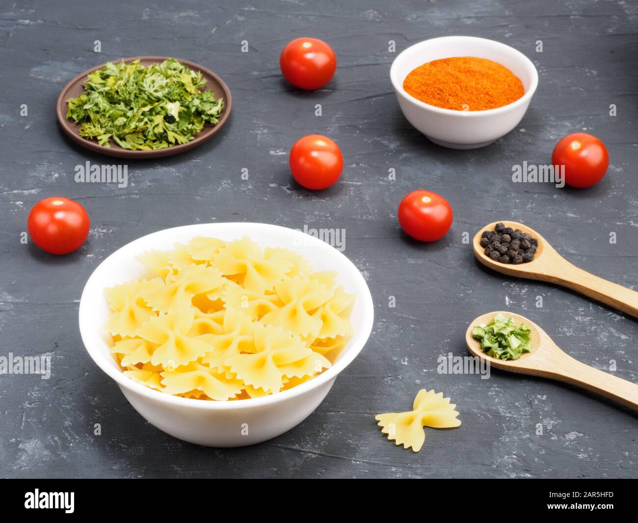asta in wooden bowl, small tomatoes, red chili, green grass, black ...
