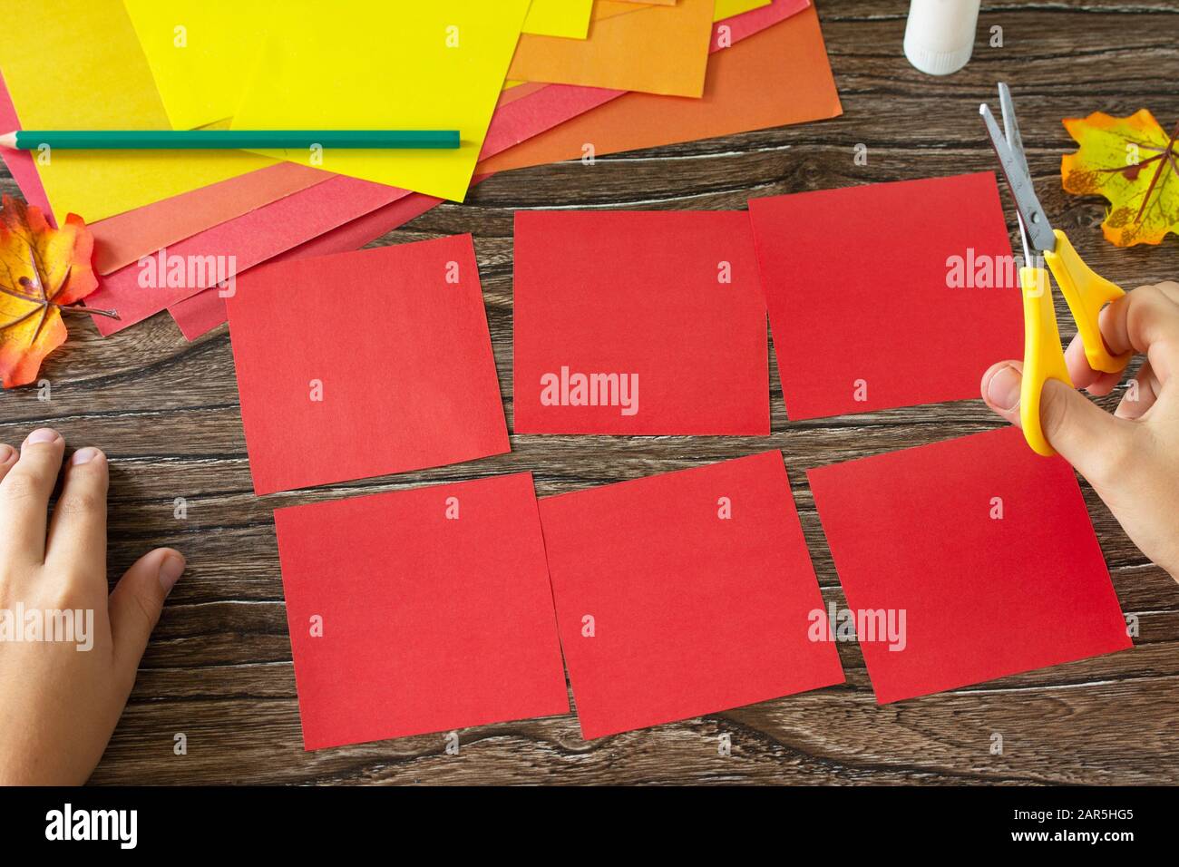 The child chopped paper leaves. Colored paper leaves in autumn on ...