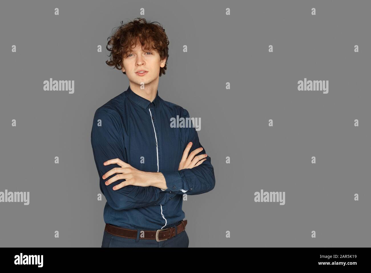 Freestyle. Teenager boy standing isolated on grey crossed arms looking ...