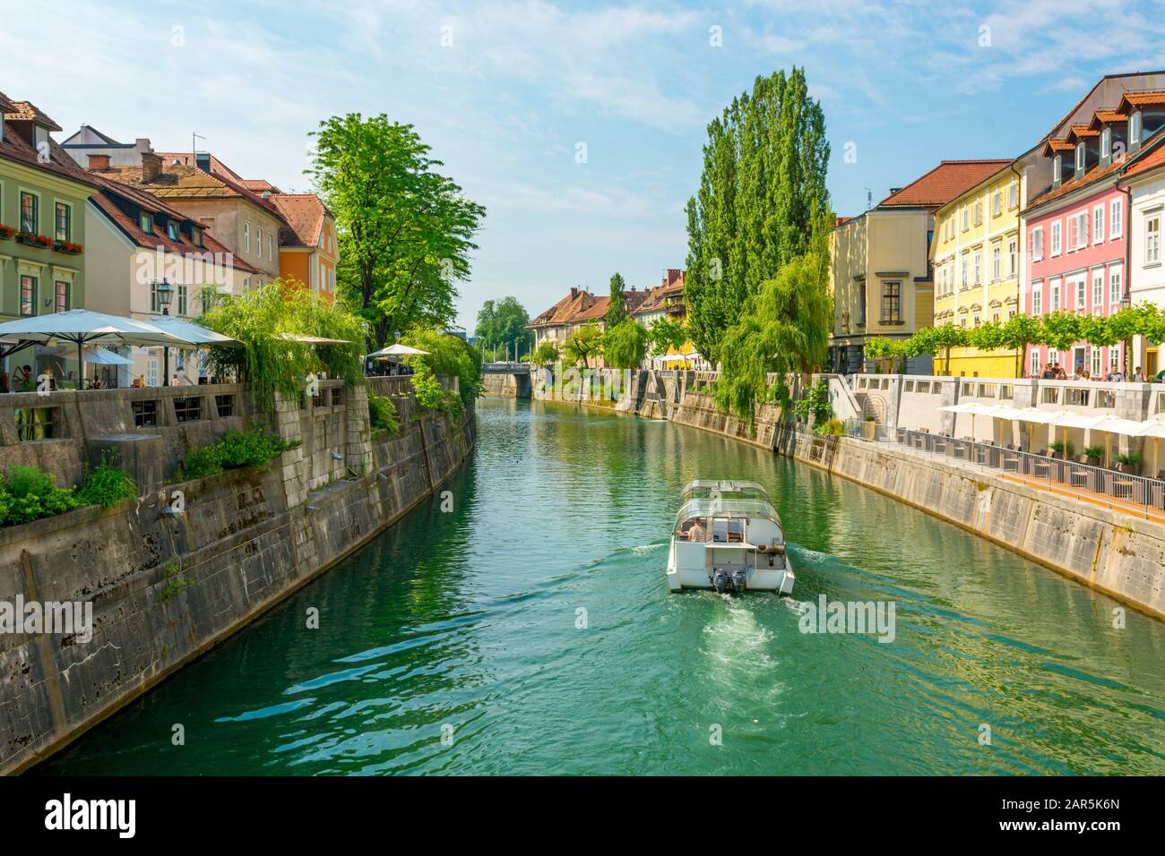 Boat floating down the river passing colorful building Stock Photo - Alamy