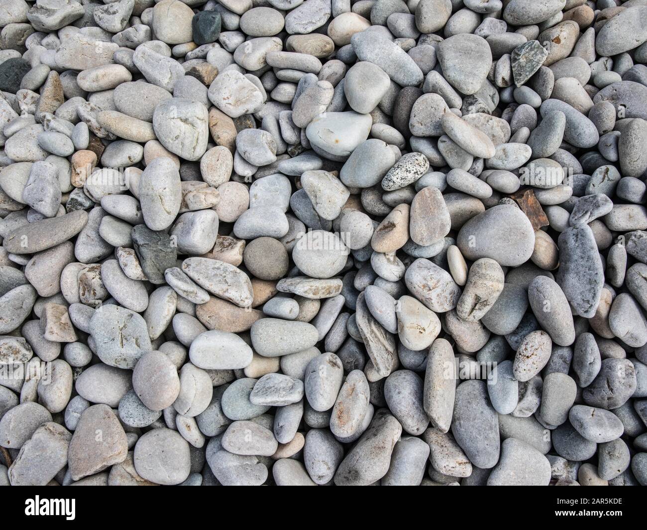 Mixed beach pebble stones background Stock Photo - Alamy