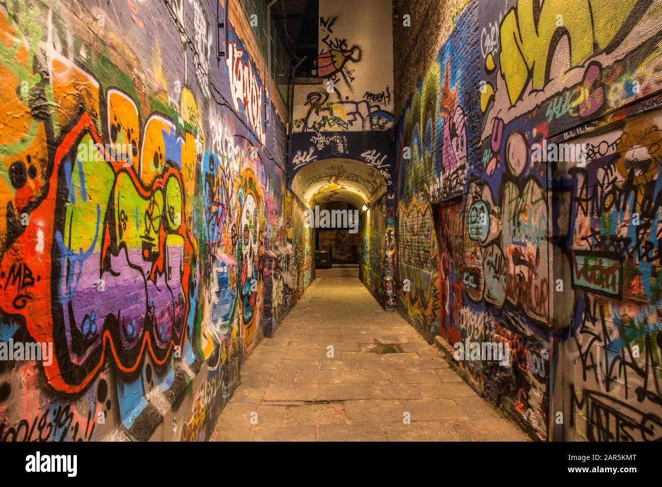 Arch in a narrow street with colorful graffiti all over the walls Stock ...