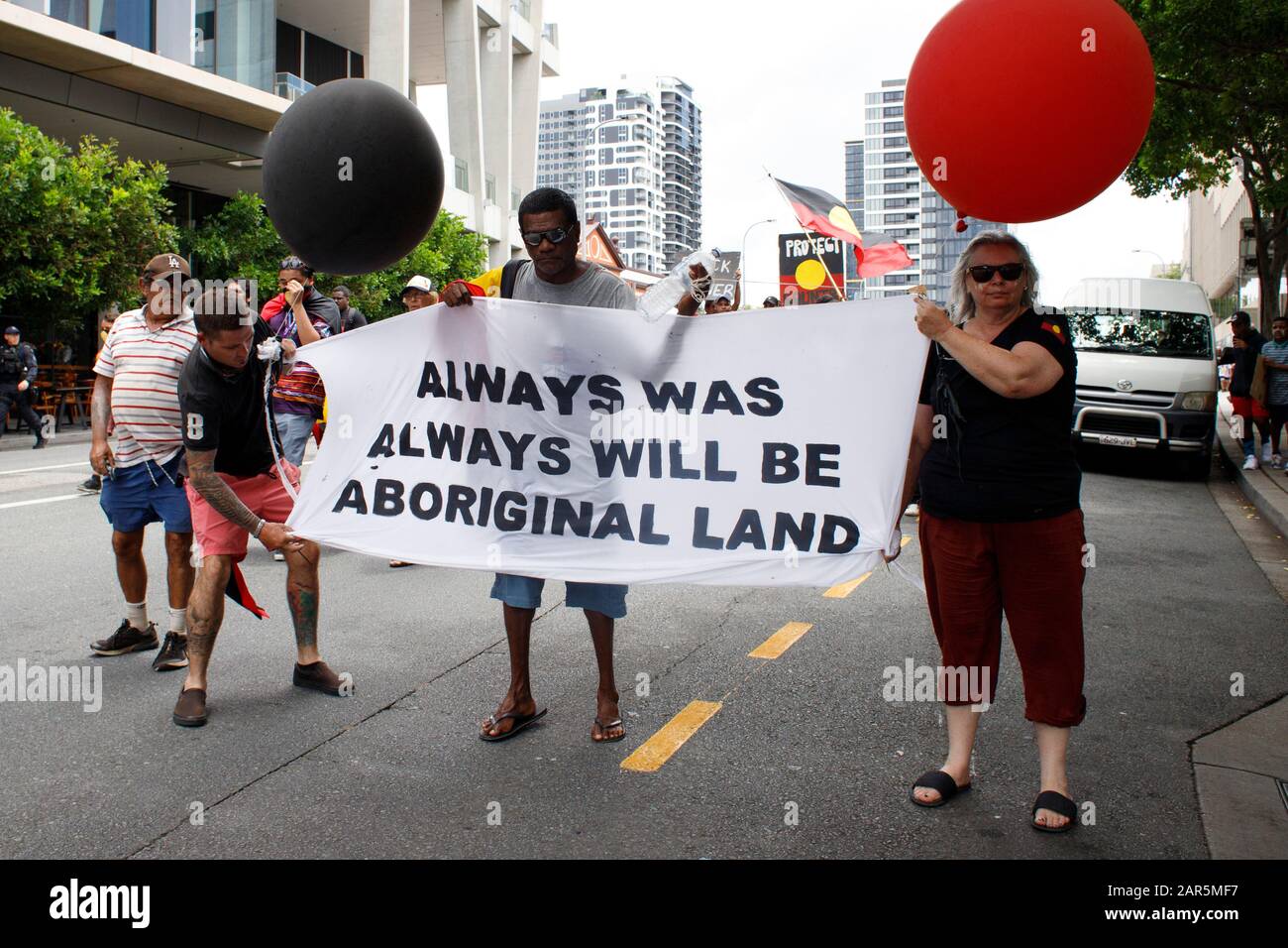 Protesters proudly hold a banner during the rally.Indigenous Yuggera ...