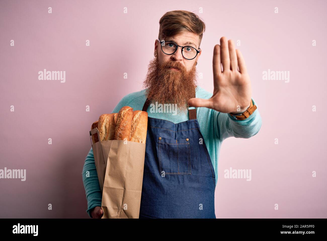 Irish redhead baker man with beard holding groceries paper bag of bread ...