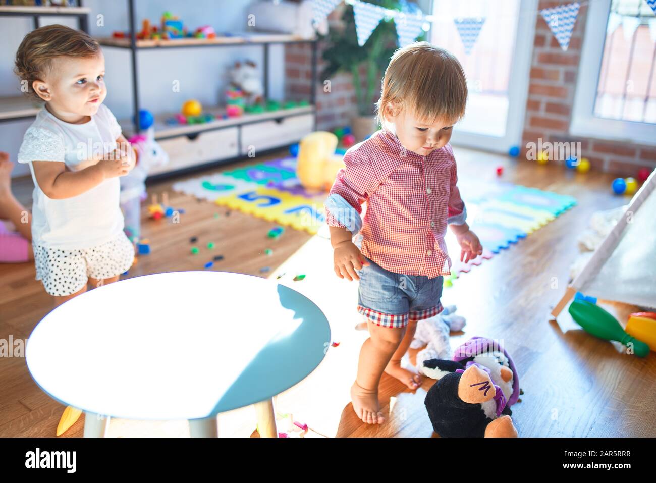Adorable toddlers playing around lots of toys at kindergarten Stock ...
