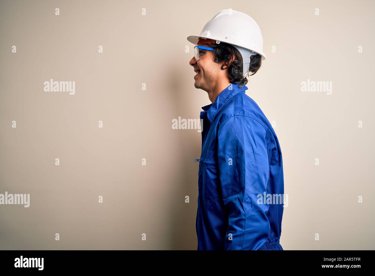 Young constructor man wearing uniform and security helmet over isolated ...