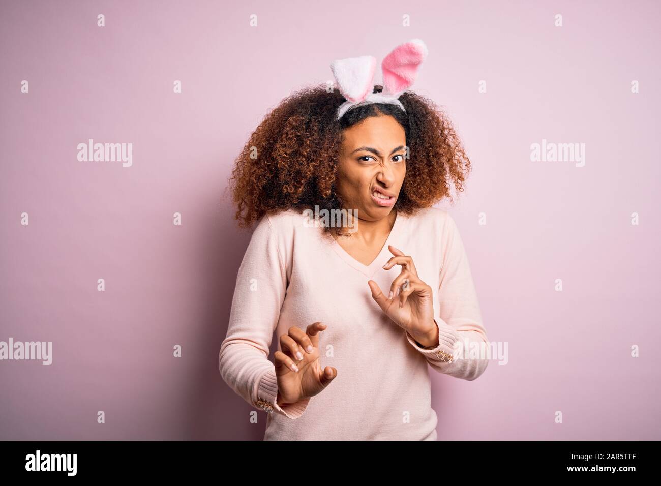 Young african american woman with afro hair wearing bunny ears over ...