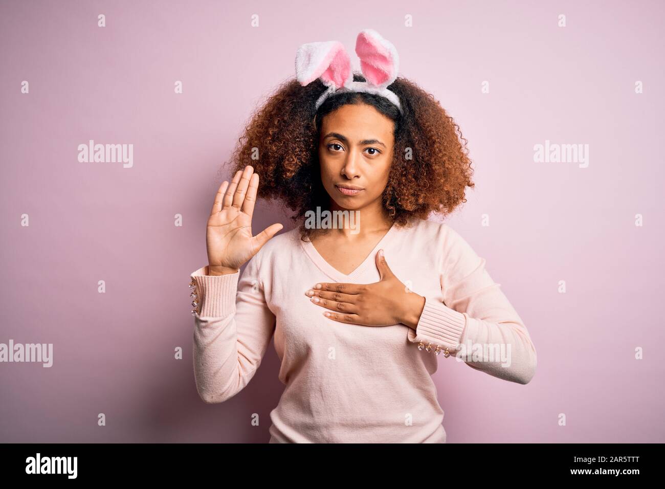 Young african american woman with afro hair wearing bunny ears over ...