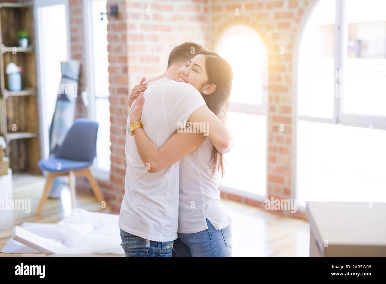 Young beautiful couple hugging at new home around cardboard boxes Stock ...