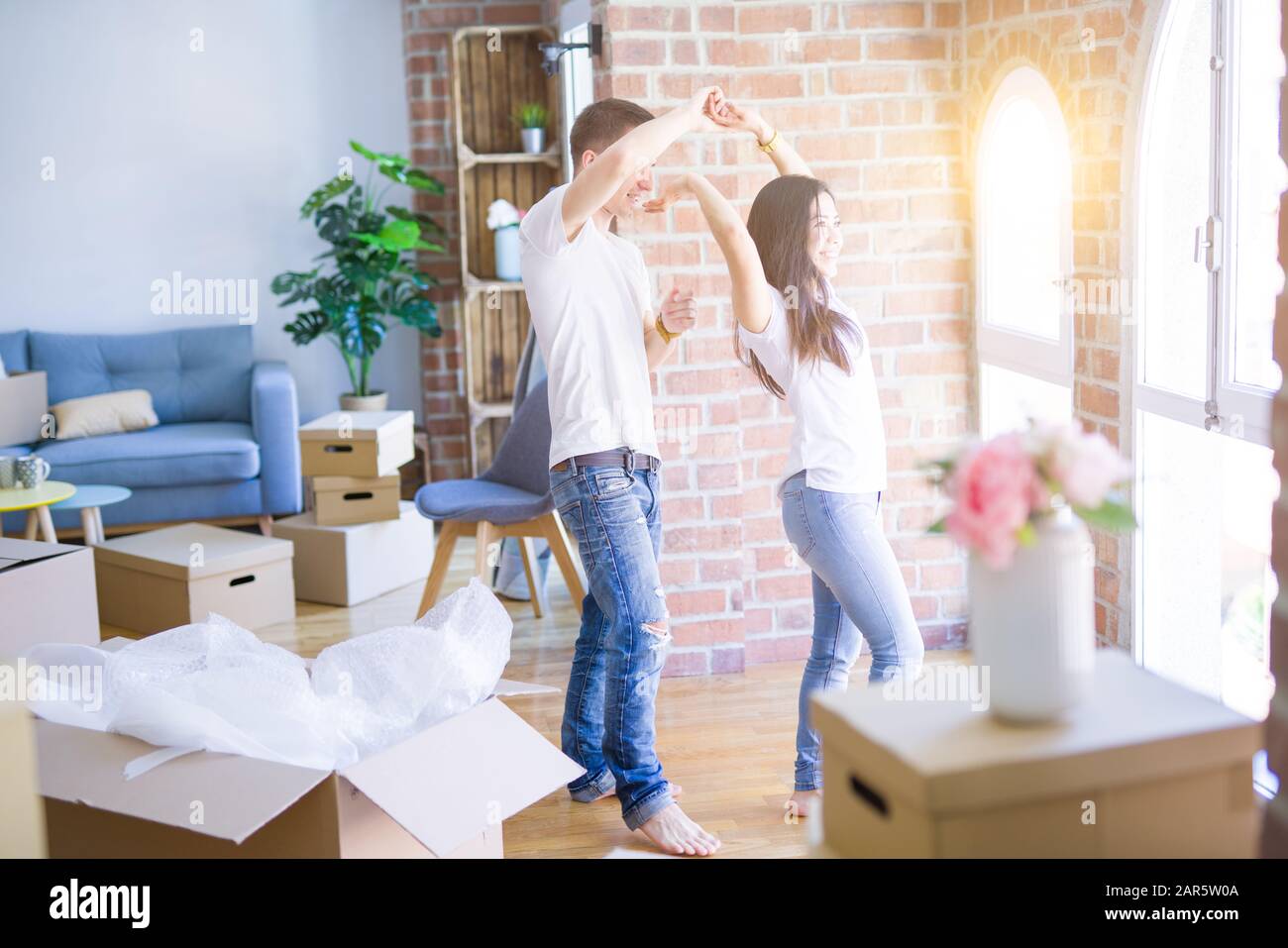 Young beautiful couple dancing at new home around cardboard boxes Stock ...