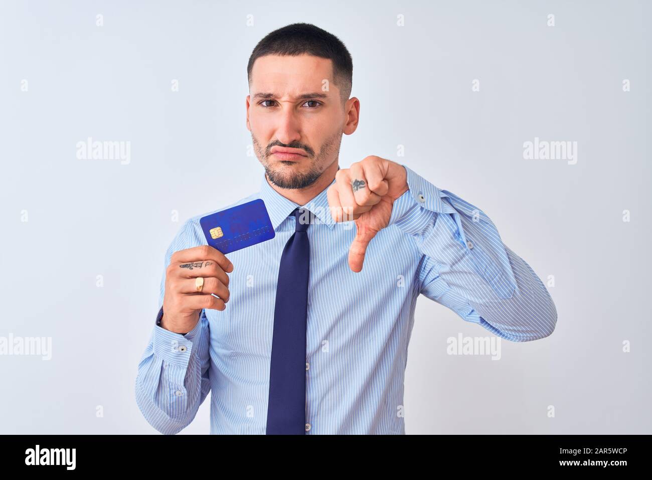 Young business man holding credit card over isolated background with ...