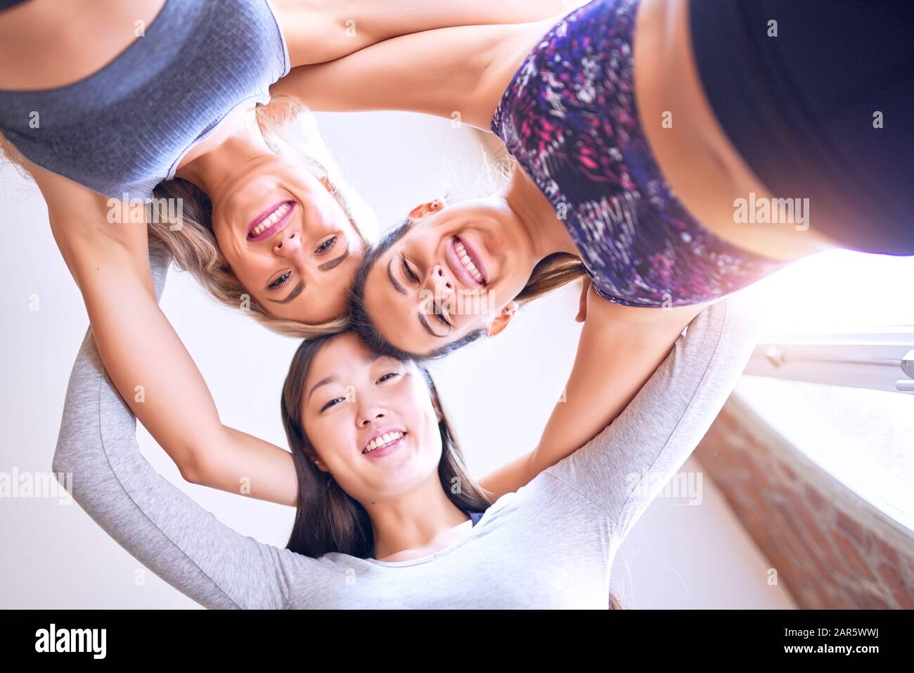 Young beautiful group of sportswomen smiling happy. Standing hugging ...