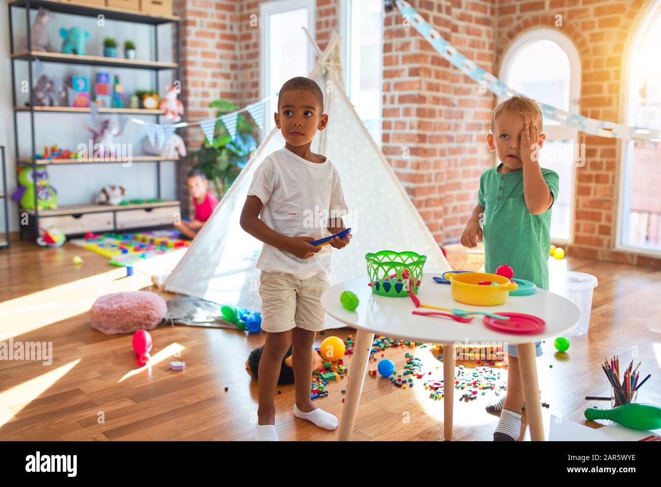 Adorable toddlers playing around lots of toys at kindergarten Stock ...