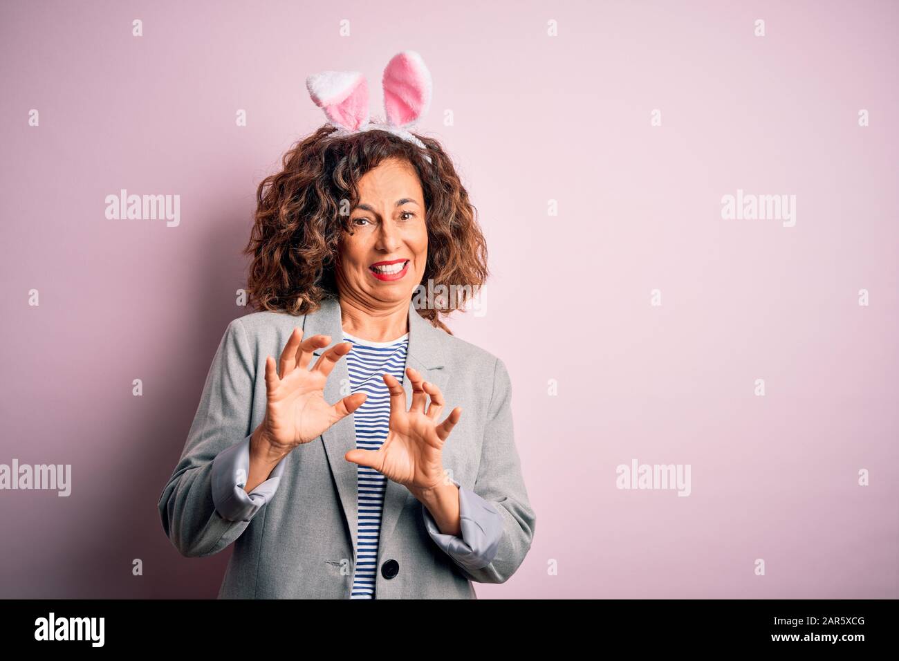 Middle age beautiful woman wearing bunny ears standing over isolated ...