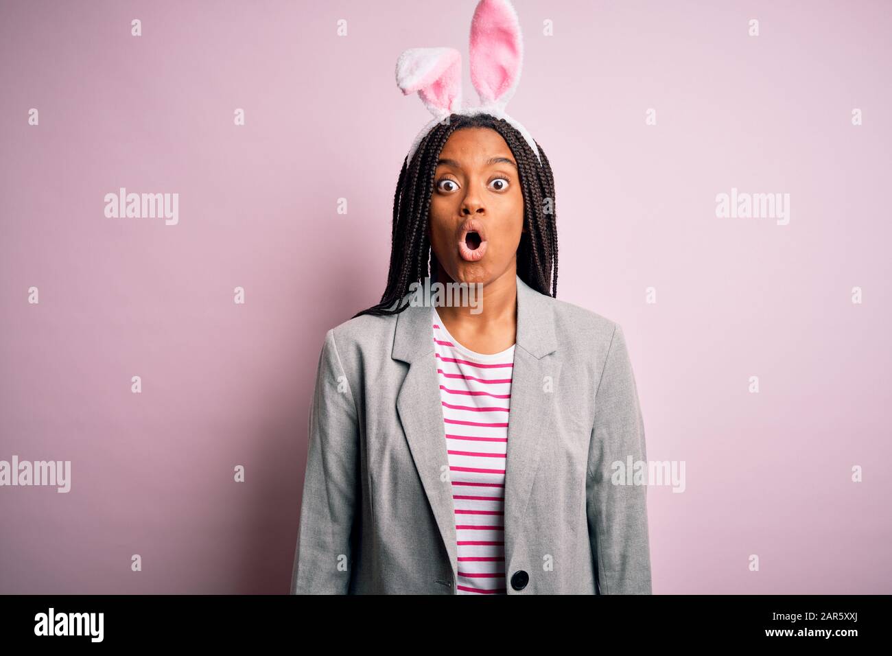 Young african american girl wearing cute easter bunny ears over pink ...