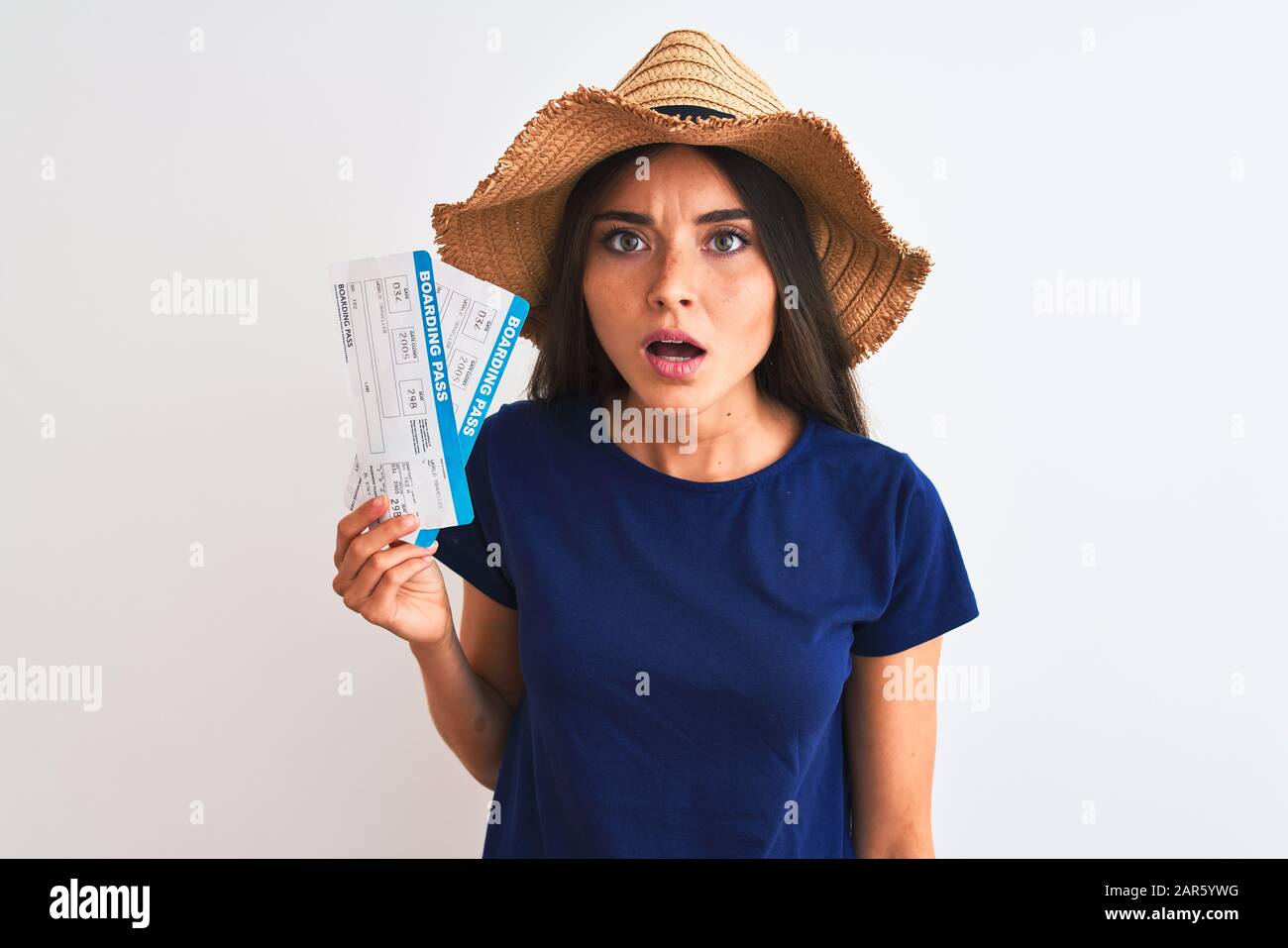 Young beautiful tourist woman holding boarding pass ticket over ...