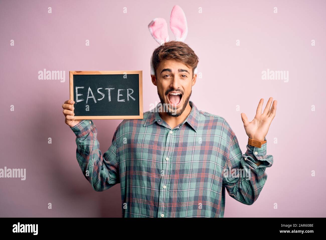 Young handsome man wearing cute easter rabbit ears and holding ...