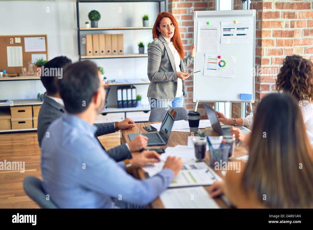 Group of business workers working together in a meeting. One of them ...