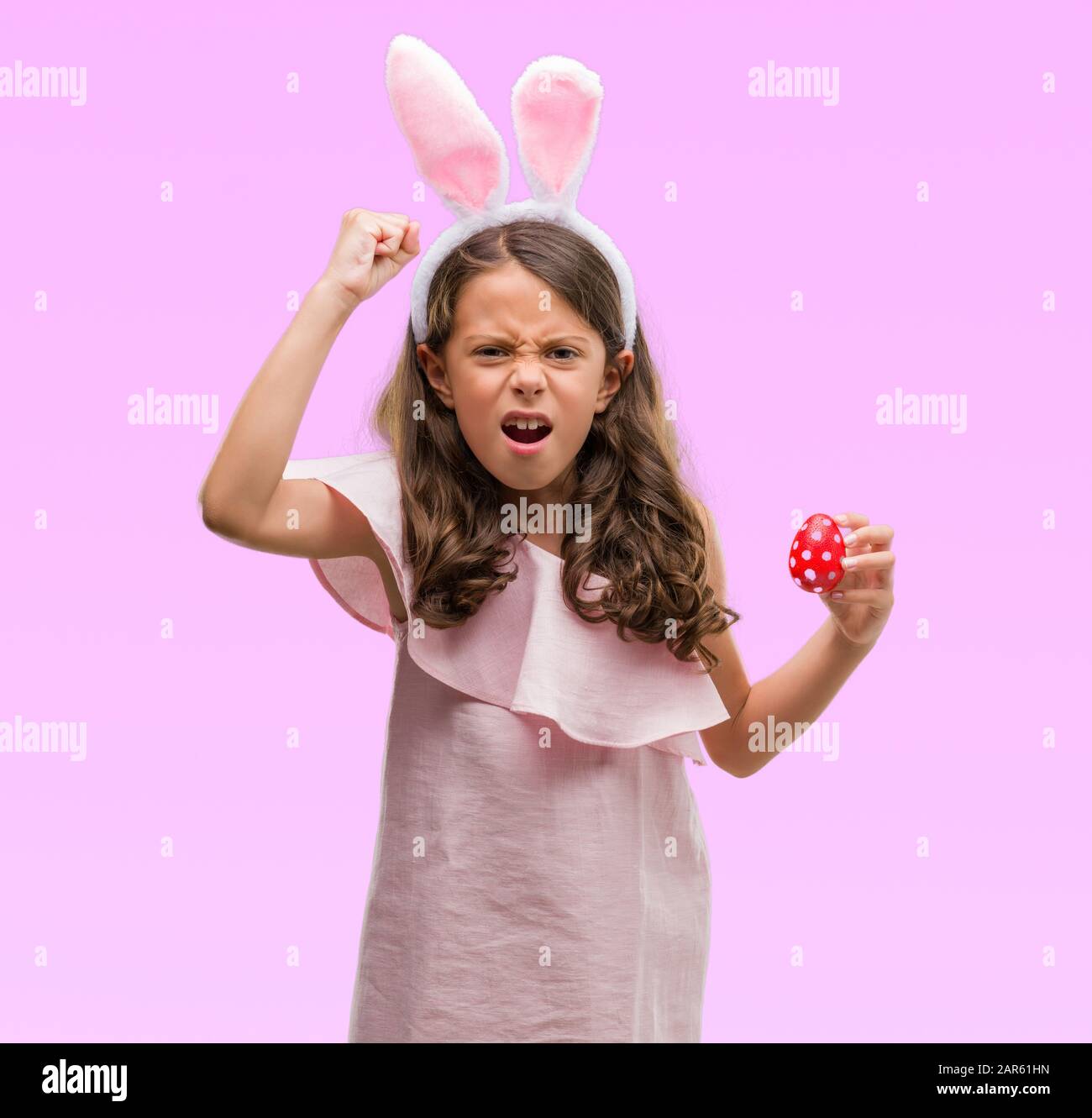 Brunette hispanic girl wearing easter rabbit ears annoyed and ...
