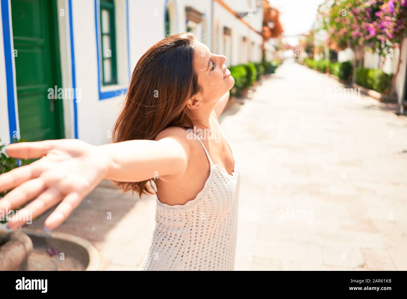 Young beautiful woman at the colorful village of Puerto de Mogan ...