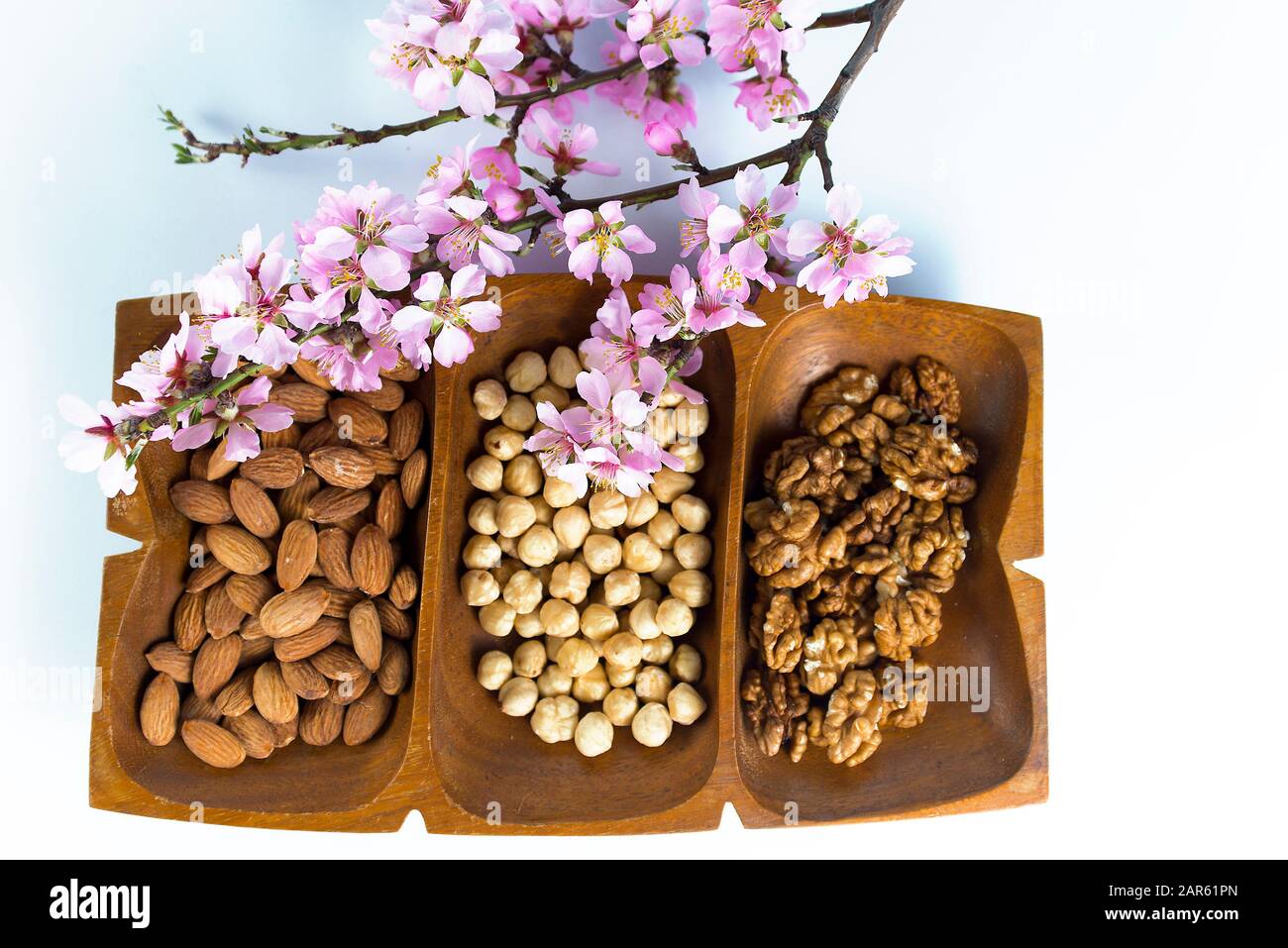 Flat laid healthy raw snack of nuts served in a wooden container, shot ...