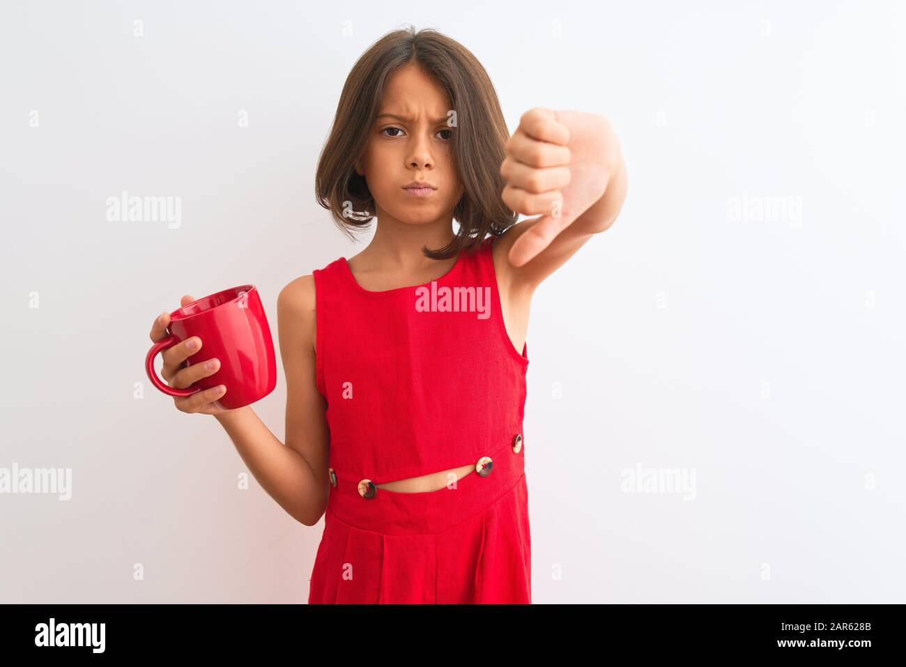 Beautiful child girl holding red cup of tea standing over isolated ...