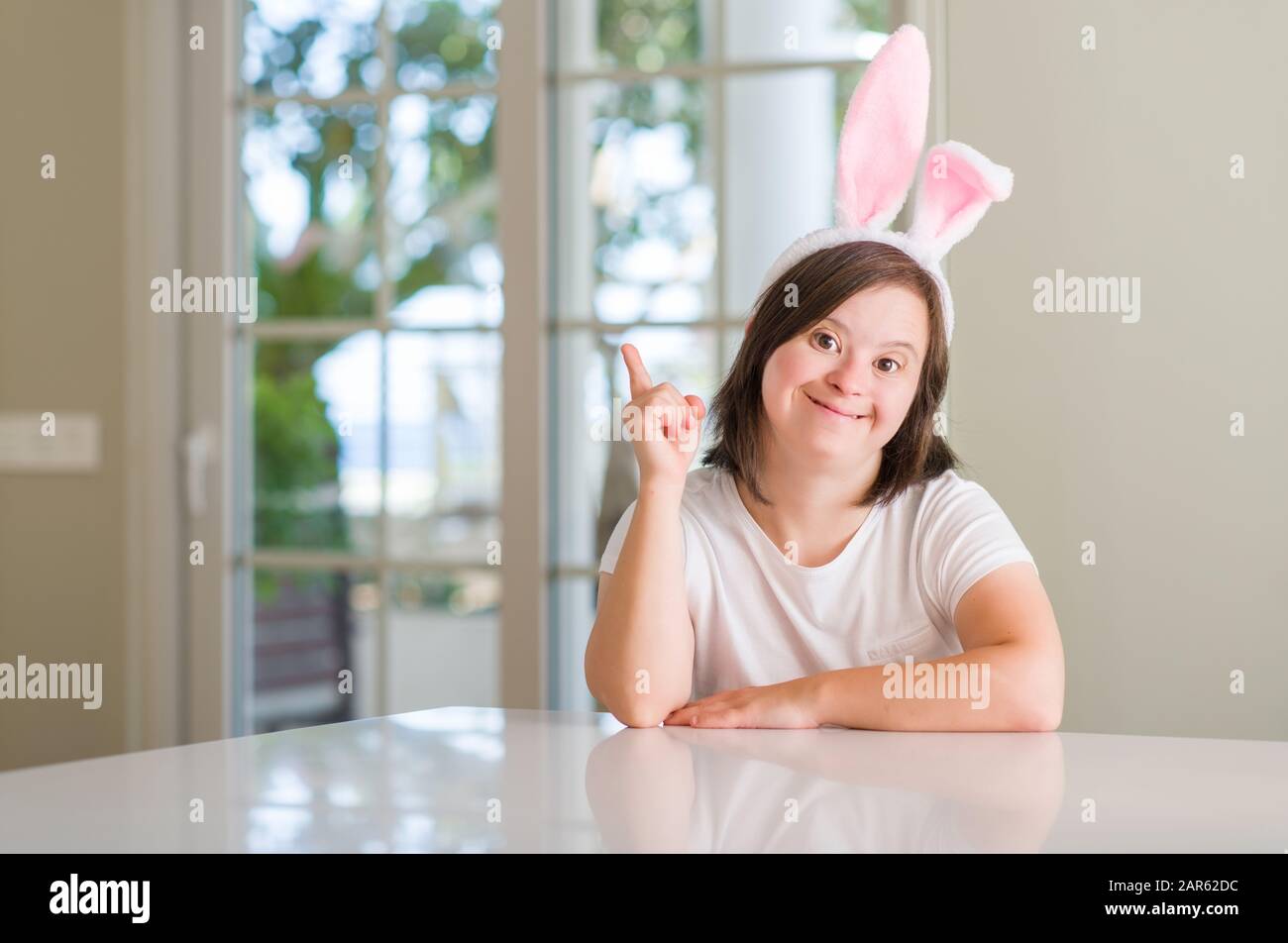 Down syndrome woman at home wearing easter rabbit ears surprised with ...