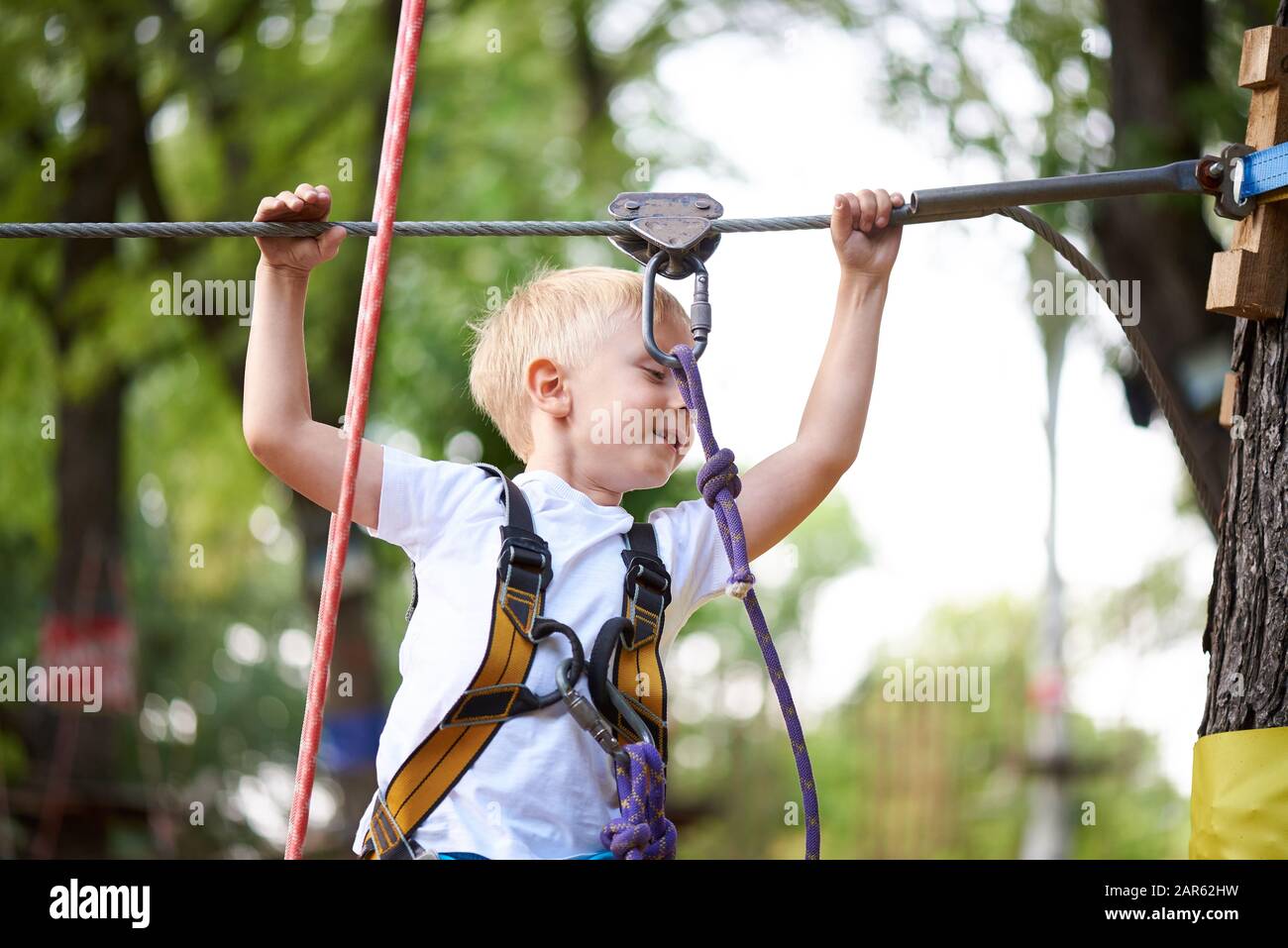 Little boy overcomes the obstacle in the rope park Stock Photo - Alamy