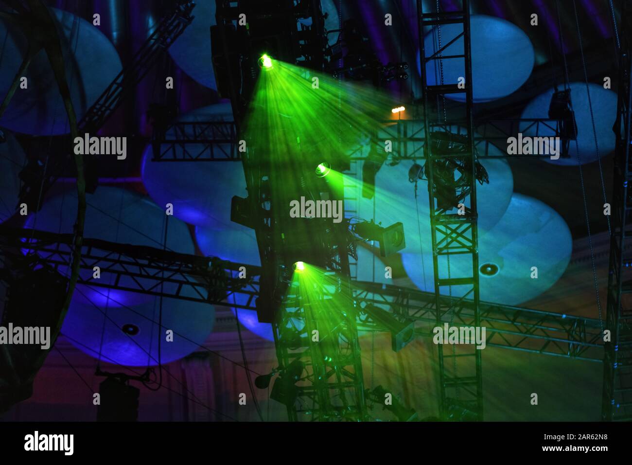 Reflector lights shining through smoke on theatre roof before ...