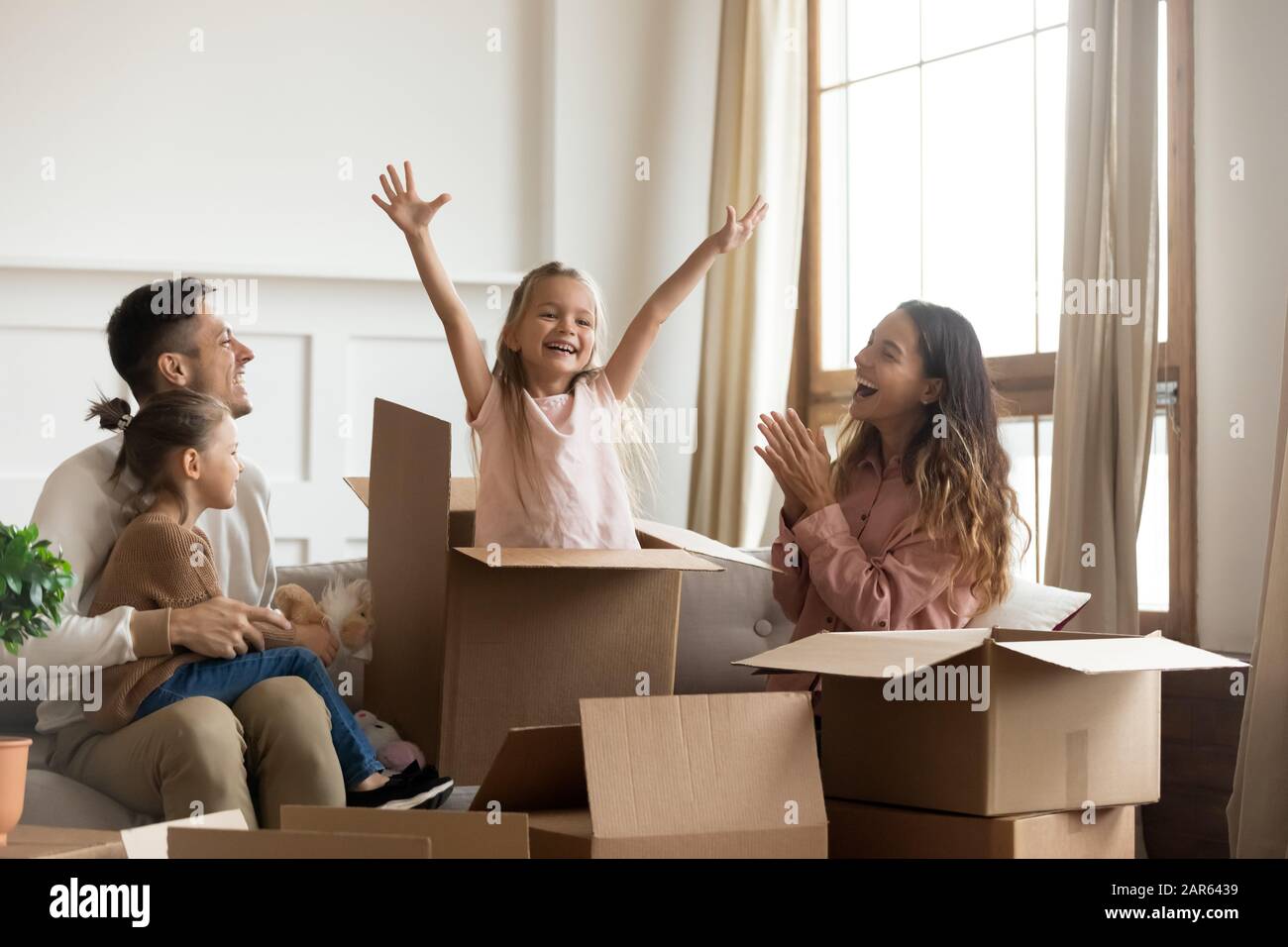 Excited young family with kids have fun unpacking together Stock Photo ...