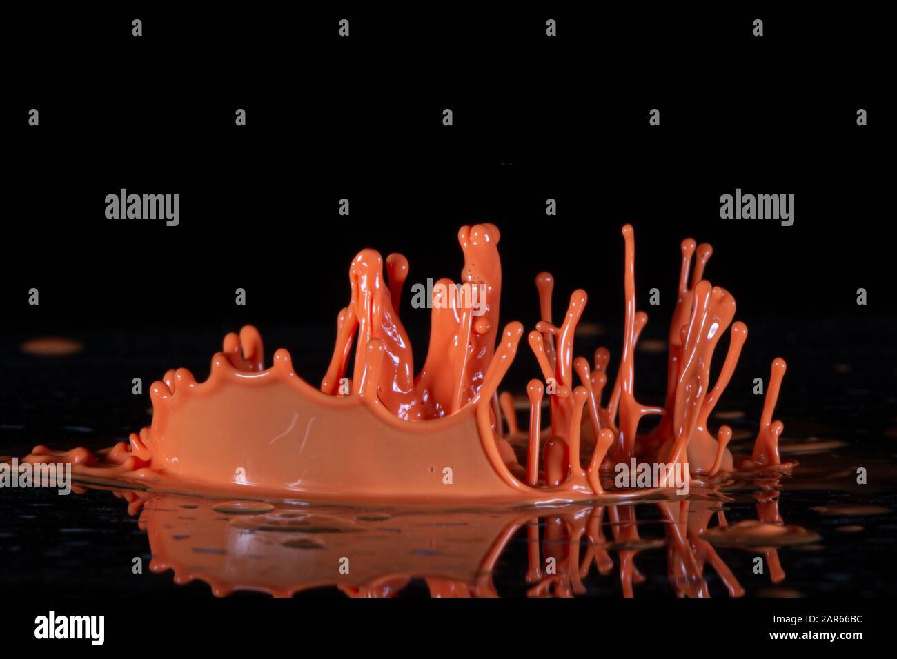 orange ink splash on a black background Stock Photo - Alamy
