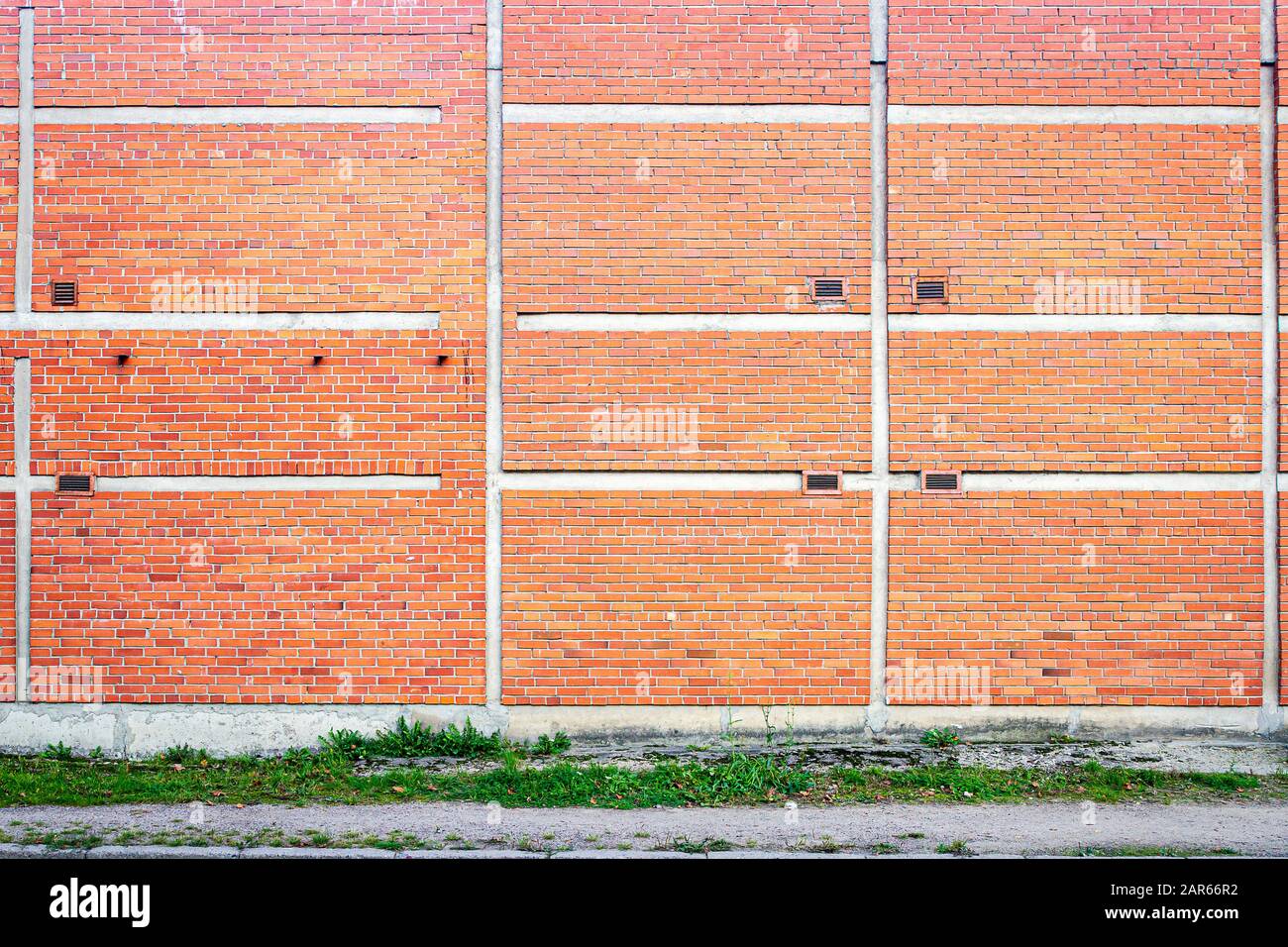 Red lined brick wall background with green grass Stock Photo - Alamy