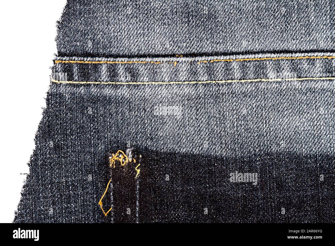 Piece of black jeans fabric with a ripped of back pocket isolated on ...