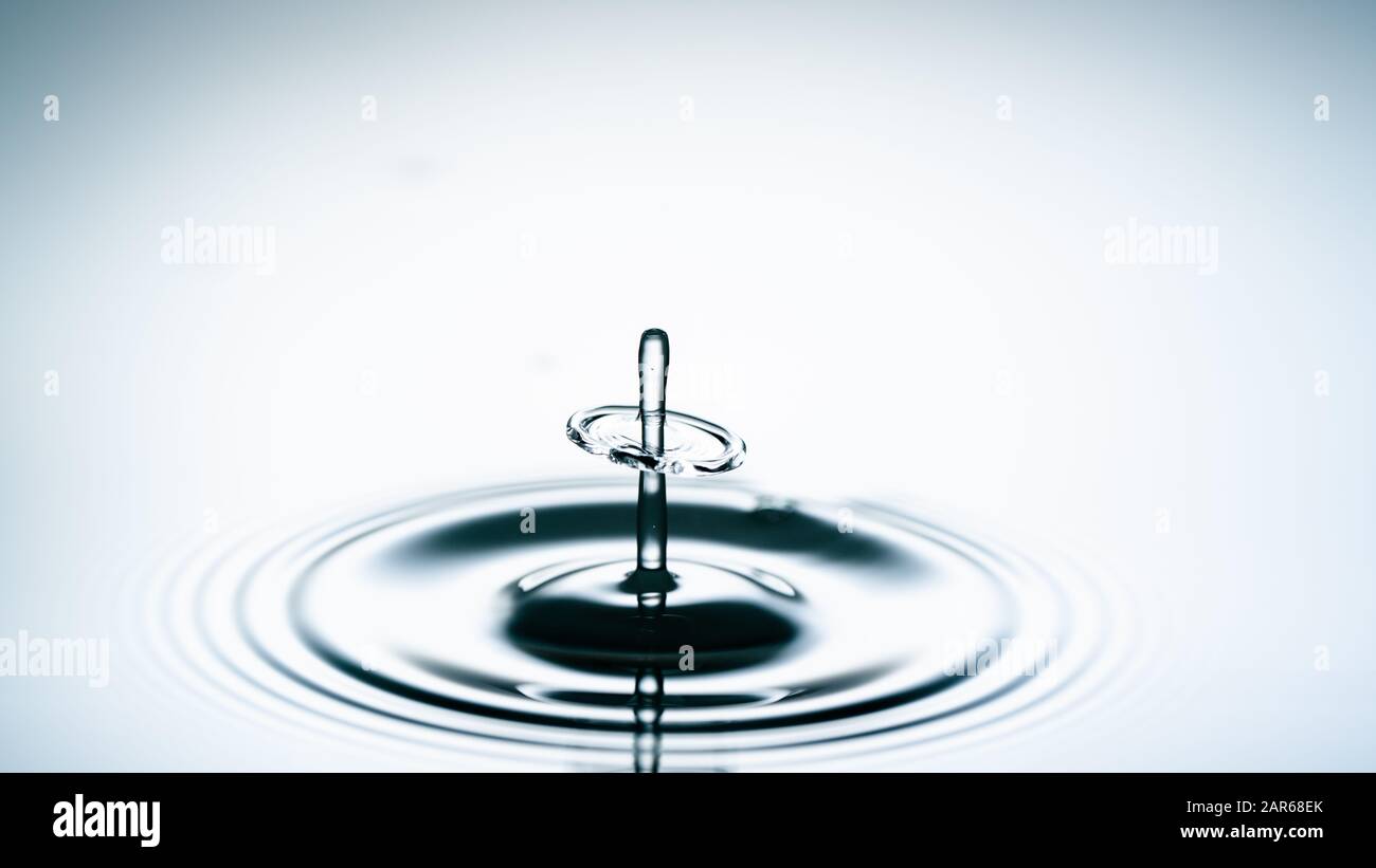 Close-up of a water drop falling on water surface Stock Photo - Alamy