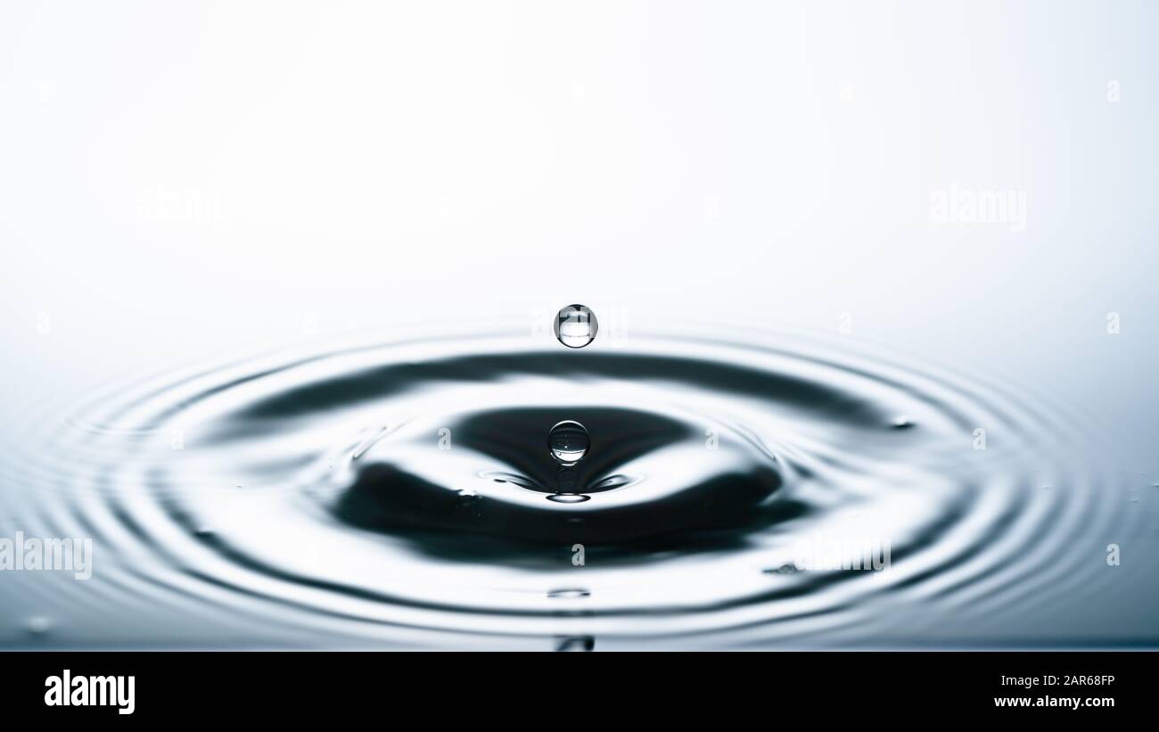 Close-up of a water drop falling on water surface Stock Photo - Alamy