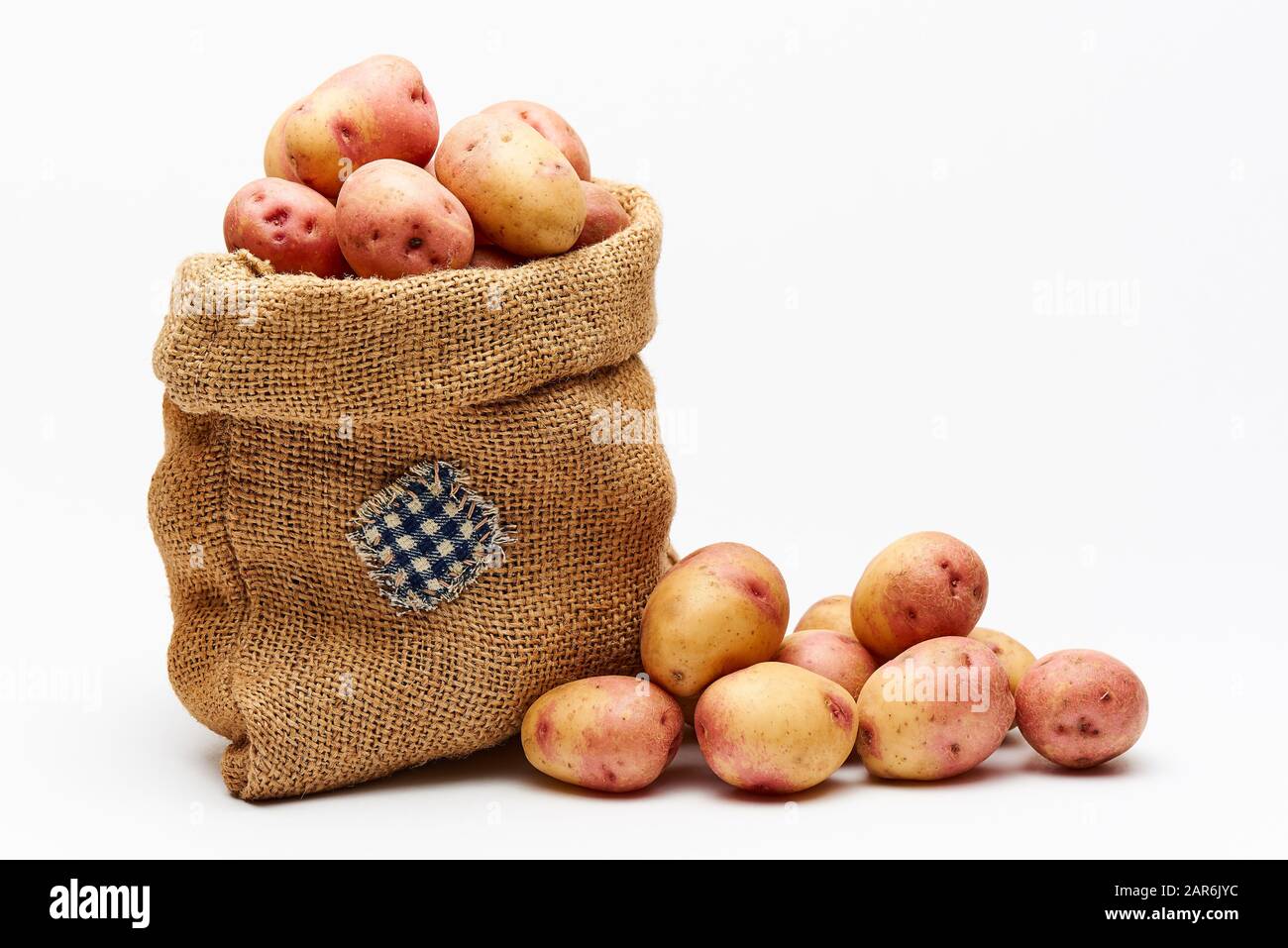 Bag with potatoes on a white background Stock Photo - Alamy