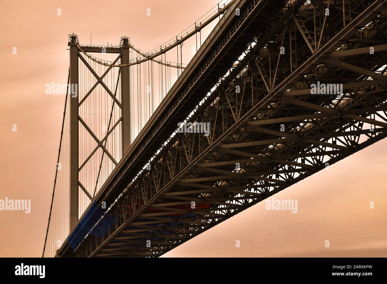Forth Road Bridge (built 1964) from below with orange sky. This bridge ...