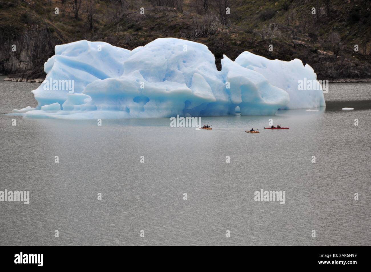 tourists in kayak get close to an ice berg at Lago Grey, Torres del ...
